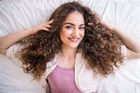 Portrait Of Beautiful Young Woman With A Curly Hair Lying On Her Back