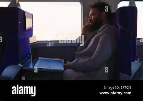 An African American Businessman On A Train Is Focused On A Phone Call