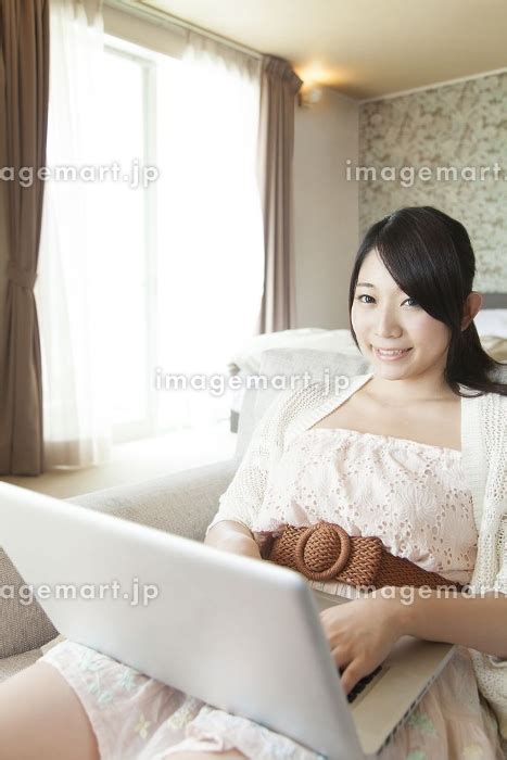 ソファーに座りノートpcを操作する女性の写真素材 23984522 イメージマート