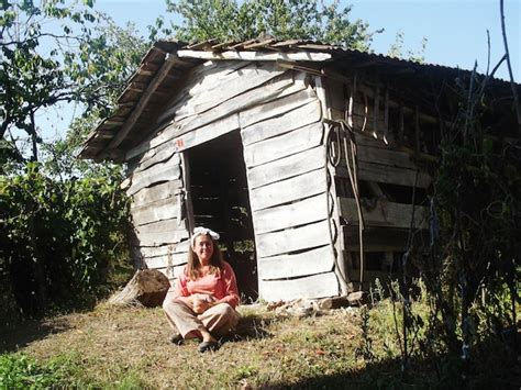 Premium Photo Portrait Of Woman Sitting On Field Against Barn