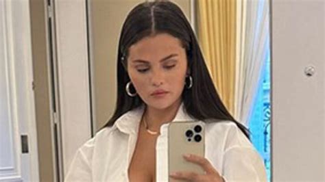 Selena Gomez puts on a sultry display in a plunging button-down shirt dress and over-the-knee ...