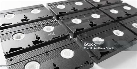 배경에 흩어져있는 테이프가있는 Vhs 테이프 뒷면을 들고있는 손 1980 1989 년에 대한 스톡 사진 및 기타 이미지