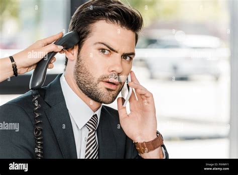 Shocked Businessman Talking By Smartphone And Secretary Giving Him