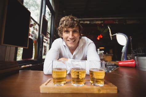 Free Photo Portrait Of Bartender With Tray Of Whisky Shot Glasses At