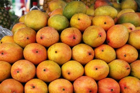 Premium Photo Pile Of Delicious Ripe Yellow Mangoes Closeup