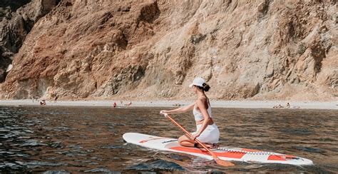 여자는 요가를 한다 패들 섭 서핑보드에서 요가 필라테스를 연습하는 행복한 스포티한 여성 바닷물에서 운동을 하는 여성 스트레칭 현대 개별 여성 힙스터 야외 여름 스포츠 활동