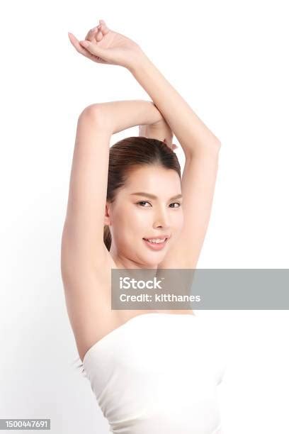 หญิงสาวชาวเอเชียที่สวยงามยกมือขึ้นเพื่อแสดงรักแร้หรือใต้วงแขนที่สะอาด