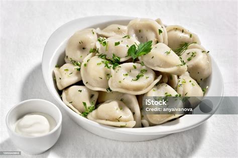 흰 그릇에 삶은 펠메니 펠메니는 얇은 밀 반죽에 싸여 다진 만남 과 수제 파스타입니다 사이드에 작은 세라믹 핀치 그릇에 사워 크림 소스 러시아 문화에 대한 스톡 사진 및