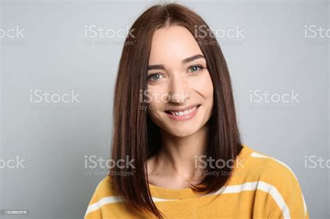 밝은 회색 배경에 화려한 밤 머리와 매력적인 미소와 예쁜 젊은 여자의 초상화 25 29세에 대한 스톡 사진 및 기타 이미지