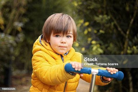 어린 아이를 울고 카메라를 보고 밝은 노란색 재킷에 스쿠터를 타고 그의 뺨에 눈물 귀여운 유아의 클로즈업 초상화 어린이 감정 2 3 살에 대한 스톡 사진 및 기타 이미지