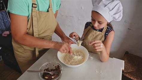 Mother And Daughter Cooking Together And Preparing Batter In The