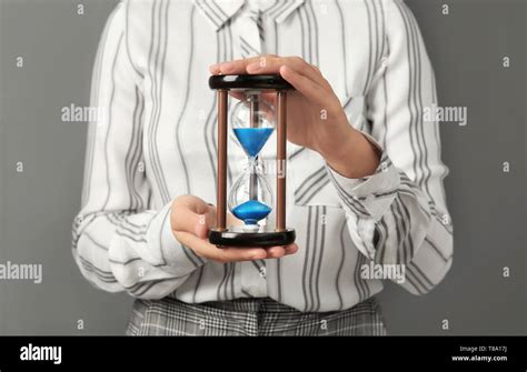 Woman Holding Hourglass On Grey Background Time Management Concept
