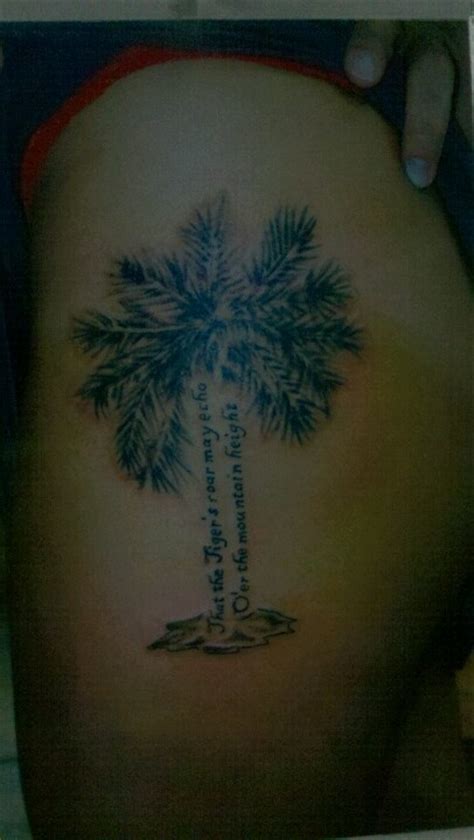The Back Of A Womans Stomach With A Palm Tree Tattoo On Her Belly