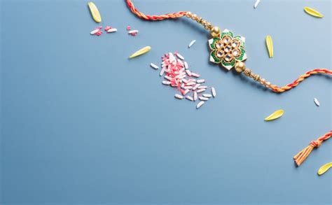 Raksha Bandhan 아름다운 Rakhi 쌀 곡물 및 꽃이있는 인도 축제 자매와 형제 간의 사랑의 상징인 인도 전통 손목