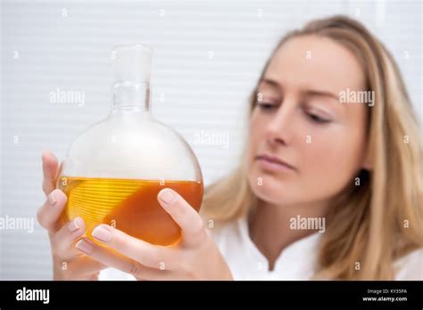 Female Researcher Holds A Large Chemical Flask With Golden Liquid Stock Photo Alamy