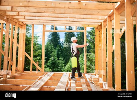 Laborer Constructing Wooden Frame House Near Forest Man Treating Woods