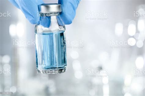 블루 메디컬 장갑에 손을 얹고 블루 액체를 가진 백신 바이알을 들고 있는 헬스케어 컨셉 건강관리와 의술에 대한 스톡 사진 및