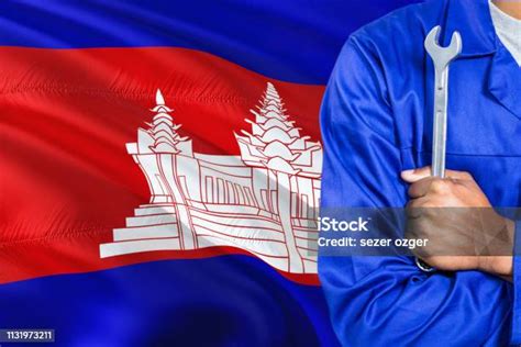 블루 유니폼 크메르어 정비사는 캄보디아 국기의 배경을 흔들며에 대 한 렌치를 들고 있다 교차 무기 기술자 교통수단에 대한 스톡 사진 및 기타 이미지 Istock