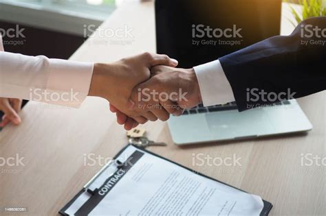 회의에서 사업가와 사업가들이 손을 잡고 있다 주택 거래에 대한 성공적인 거래는 테이블 위에 서류를 약속했습니다 30 34세에
