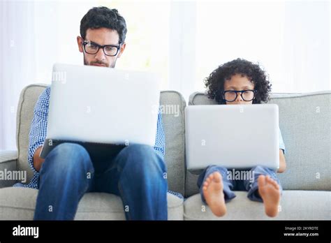 Like Father Like Son A Father And Sone Using Laptops On The Living Room Sofa Stock Photo Alamy