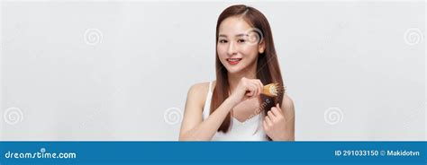 Pretty Asian Woman Is Combing Her Hair Isolated On The White Background