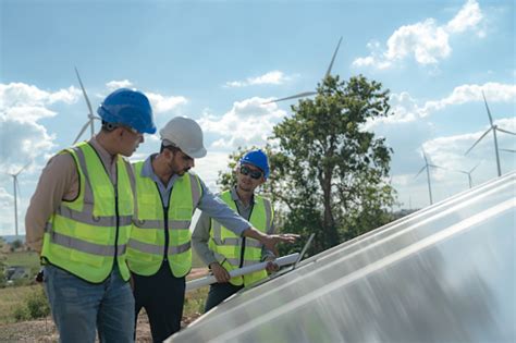엔지니어 는 전자 장치로 태양 전지 패널 또는 태양광 전지의 건설을 검사합니다 녹색 전력의 산업 재생 에너지 타워 지붕에서 일하는 공장 노동자 3 명에 대한 스톡 사진 및