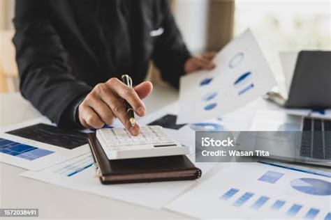 Pengusaha Mengerjakan Dokumen Yang Menganalisis Grafik Keuangan Dalam