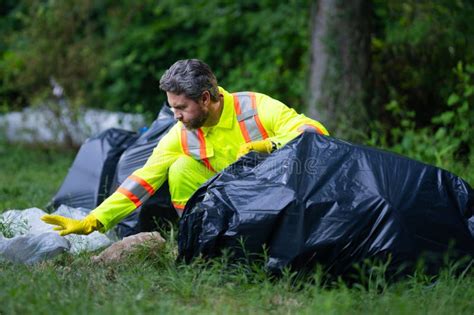 Man Cleaning Up The Park Putting Trash In A Garbage Bag Environmental Protection Stock Image