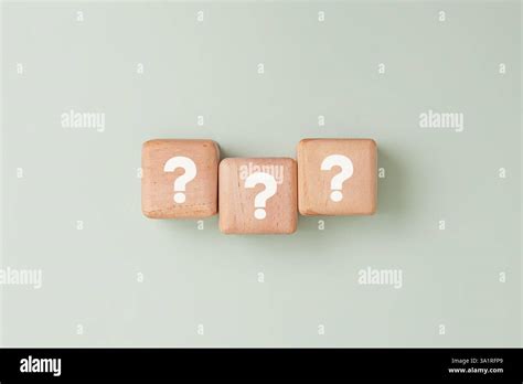 Three Wooden Blocks With White Question Marks In Straight Line Against