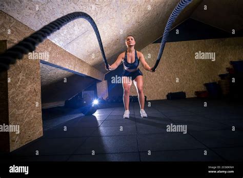 Athletic Young Woman Doing Some Cross Fit Exercises With A Rope Indoor