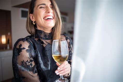 우아하게 옷을 입은 아름다운 여성이 창문 옆에 서서 화이트 와인 한 잔을 마신다 생활 방식에 대한 스톡 사진 및 기타 이미지 생활 방식 행복 12월 31일 Istock