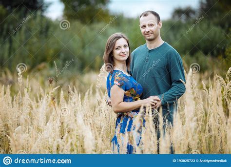 O Jovem Marido E a Esposa Abraçam se Num Campo Grama De Mãos Dadas
