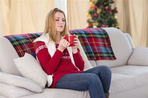Premium Photo Cheerful Cute Blonde Sitting On Couch Holding Mug