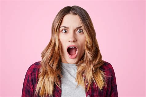 충격된 무능된 여성 학생 열고 입은 널리 체크 무늬 셔츠 핑크 배경 위에 절연 착용 내일 마지막 시험 인지 놀라게 되 고 인간의 부정적인 감정 개념 걱정하는에 대한 스톡