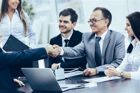Business Meeting The Table And Handshake Of Business Partners Stock