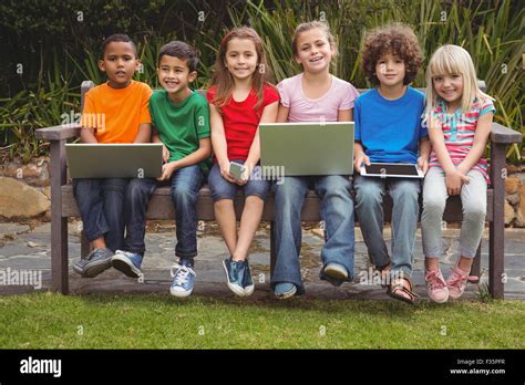 Les Enfants Assis Sur Un Banc De Parc Photo Stock Alamy