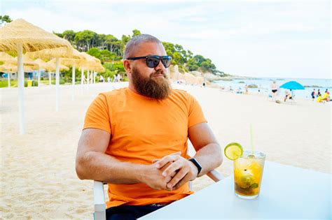 해변 카페에 앉아 있는 젊은 잘생긴 수염 남자의 초상화 또는 신선한 모히토 칵테일 한 잔과 함께 Chiringuito 30 39