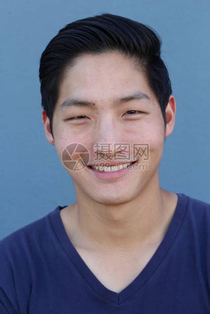 在蓝墙前穿着蓝色衬衫的英俊年轻亚洲男高清图片下载 正版图片503447968 摄图网
