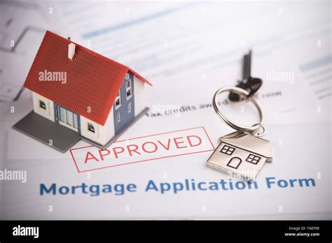 An Approved Mortgage Loan Application Form With House Key And Rubber
