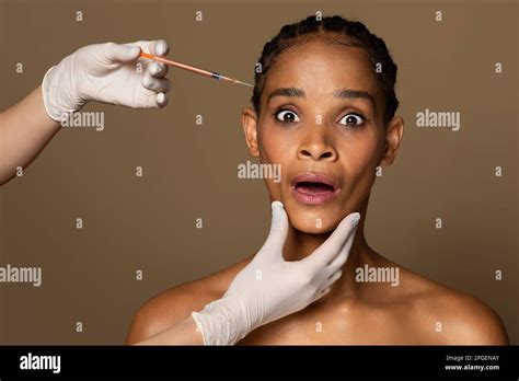 Shocked Black Middle Aged Woman Receiving Beauty Shots Using Injection