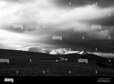 spectacular long exposure view of clouds above a path on a hill stock