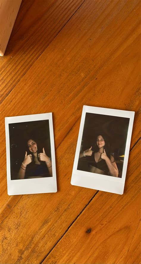 Two Polaroids Sitting On Top Of A Wooden Table