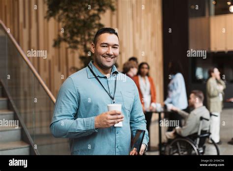 Portrait Of Smiling Male Delegate Holding Disposable Cup During Coffee