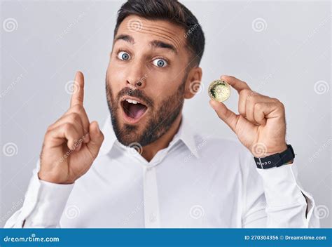 Homem Hispânico Bonito Segurando Moeda Criptomoeda De Cardano Surpreso