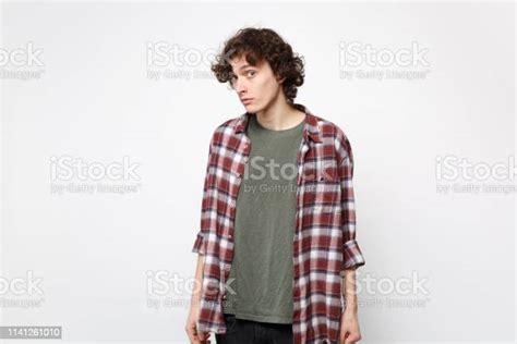 당황 당황의 초상화 서 캐주얼에 서 있는 젊은 남자 스튜디오에서 흰색 벽 배경에 고립 된 카메라를 찾고 사람들은 진심으로 감정 라이프 스타일 개념입니다 복사 공간을 모의