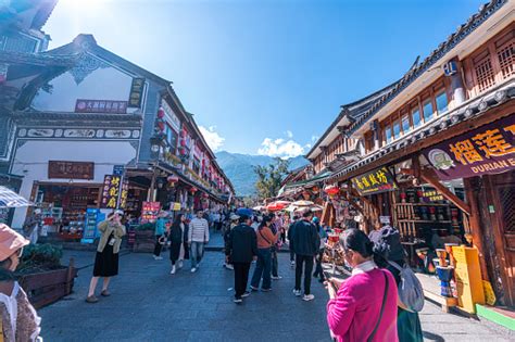 달리의 구시 가지 윈난 중국에서 화창한 날 전통적인 건축물 활기찬 상점 번화 한 활동이 늘어선 붐비는 거리 관광객과 지역 주민 모두 고대 거리를 탐험합니다 거리에 대한 스톡