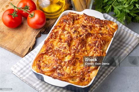 파스타 캐서롤 베카멜 소스는 녹인 모짜렐라 치즈를 얹고 테이블 위의 흰색 베이킹 접시에 담겨 제공됩니다 국수 캐서롤에 대한 스톡