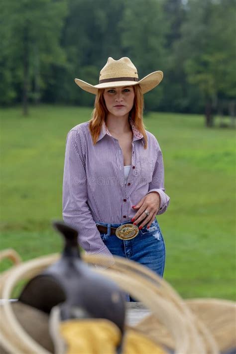 A Lovely Red Headed Country Wetern Model Poses Outdoors In A Country