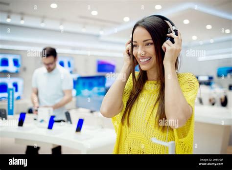 Beautiful Female Listening Music Having Headphones At Tech Store Shopping Concept Stock Photo