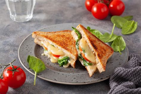 Grilled Cheese Spinach And Tomato Sandwich On Concrete Background Stock
